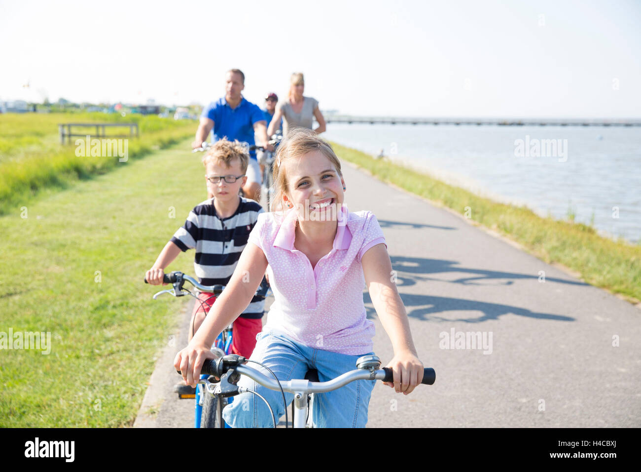Family drives bicycle by the sea Stock Photo - Alamy