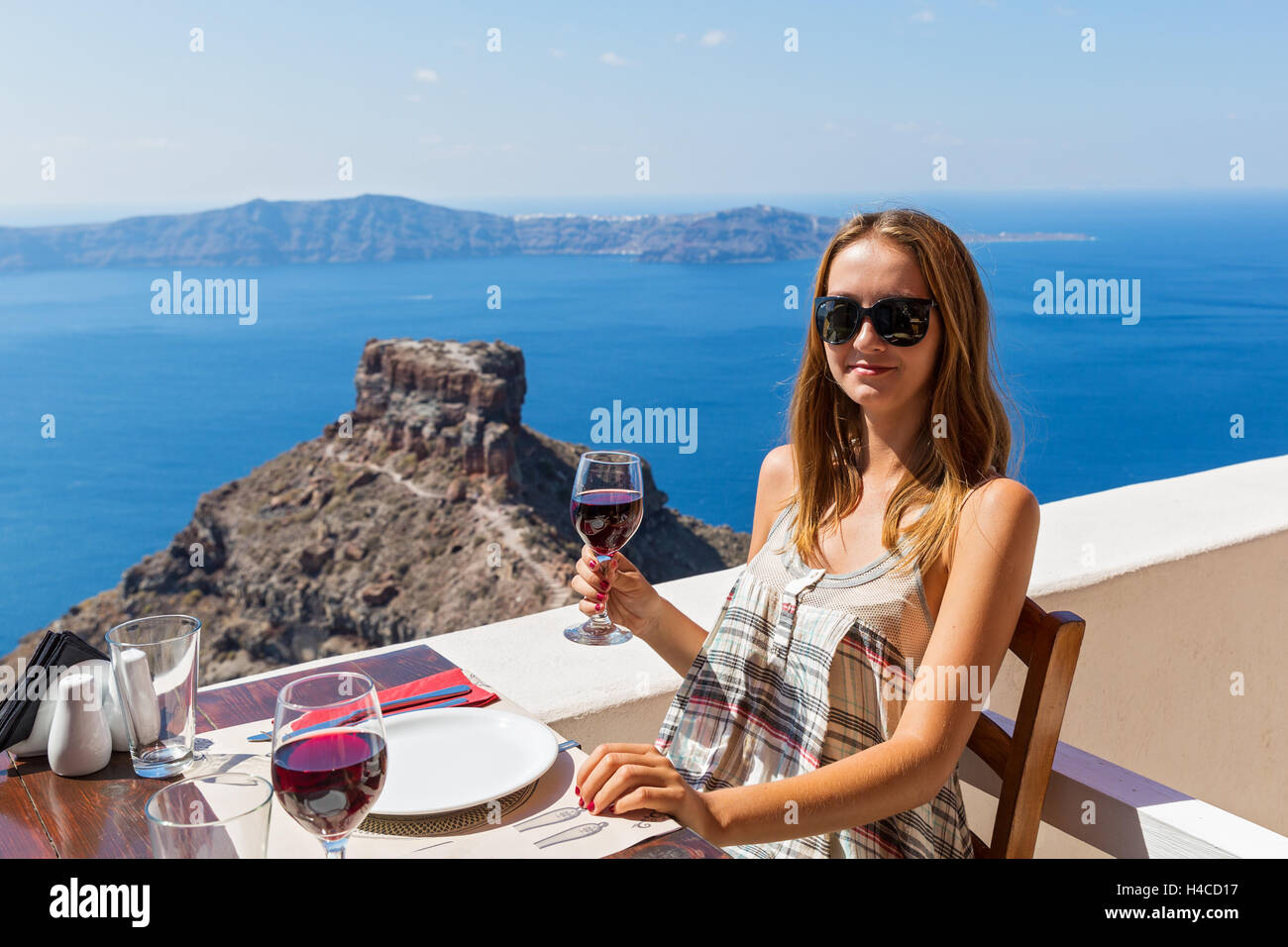 Young beautiful woman drinking red wine and watching the volcano of ...