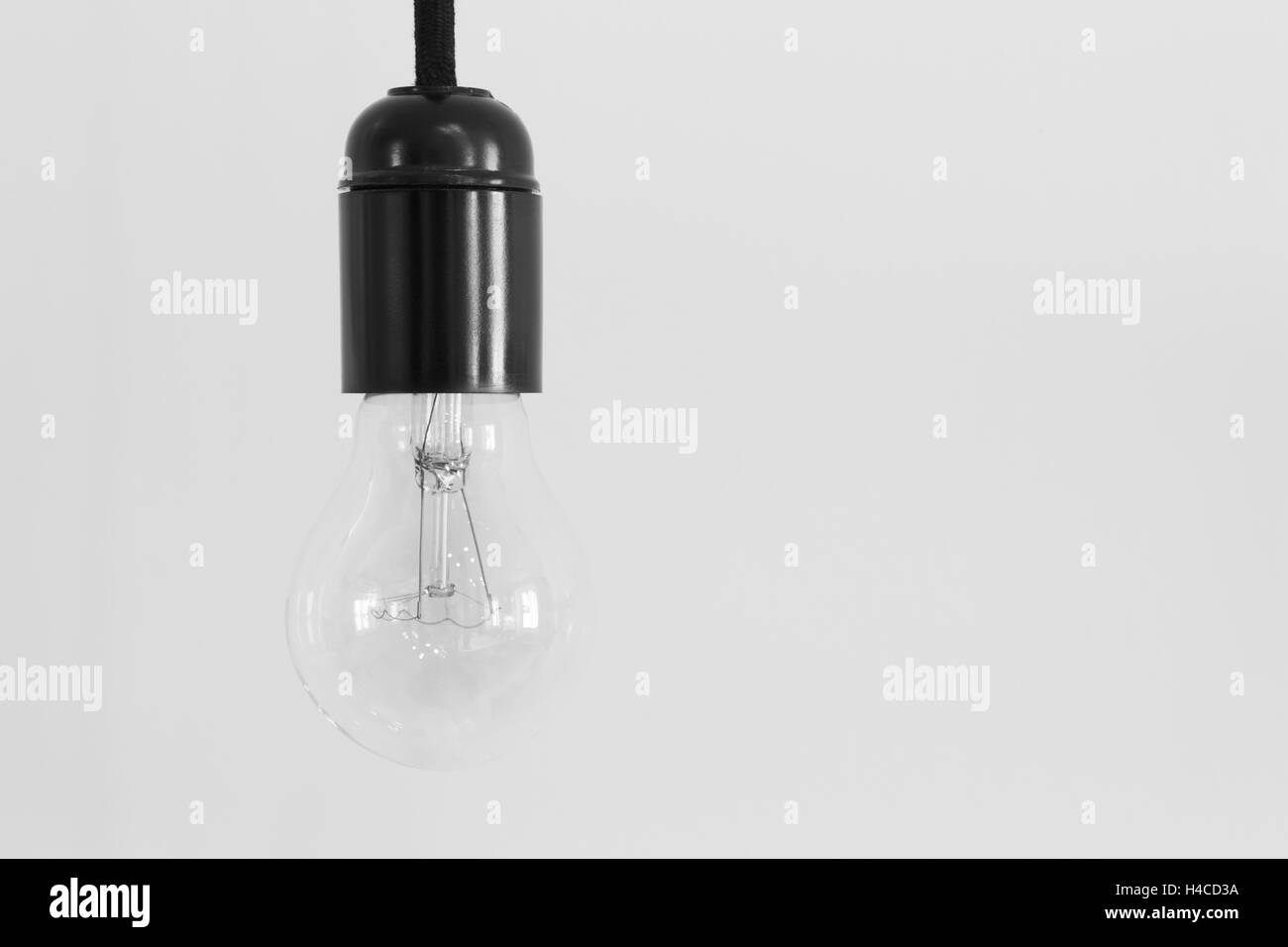 Light bulb over black background Black and White Stock Photos & Images ...