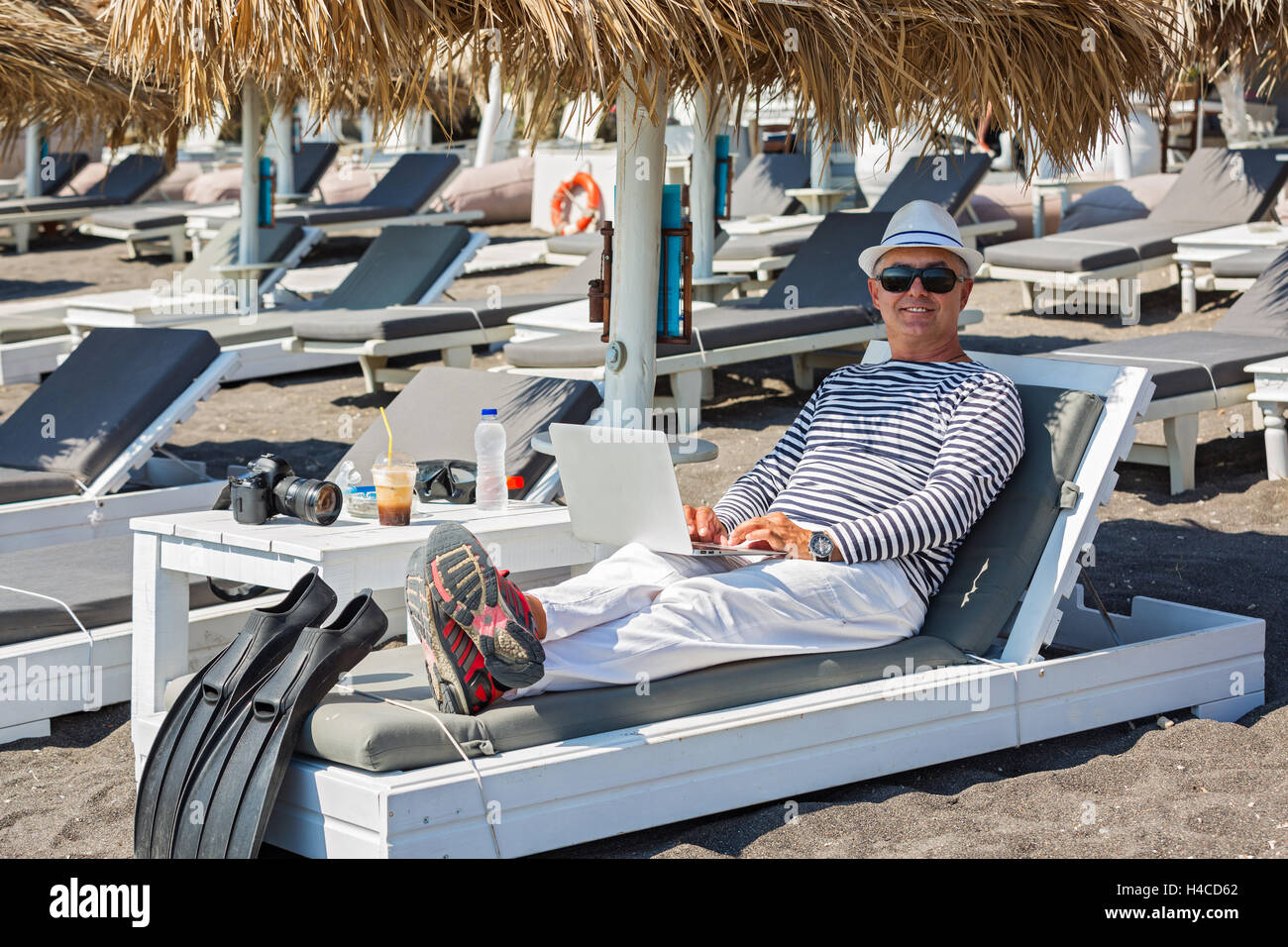 Man working at the computer lying on the beach Stock Photo - Alamy