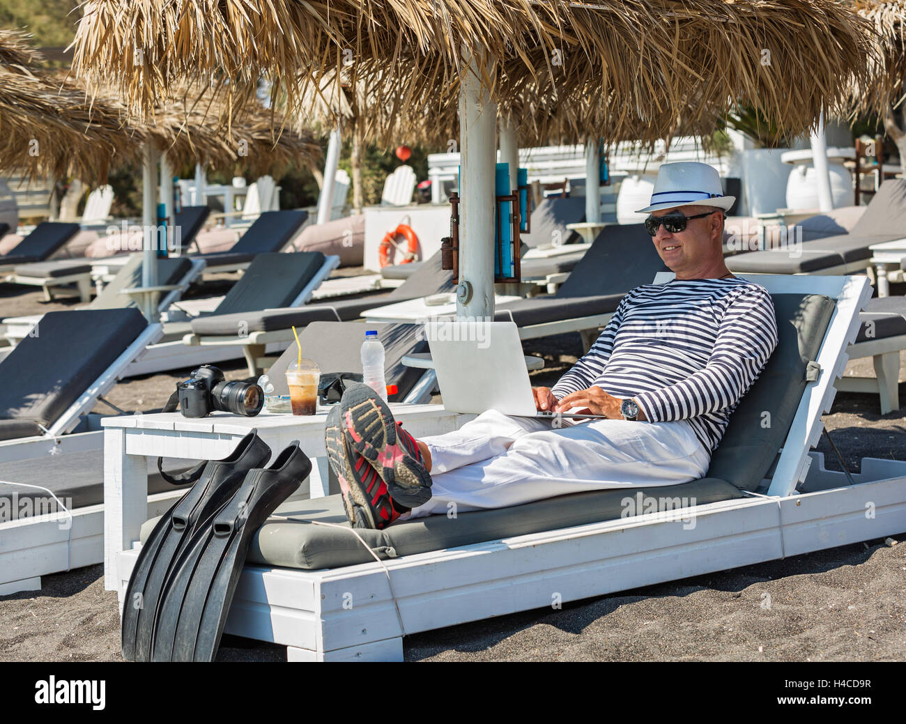 Man working at the computer lying on the beach Stock Photo - Alamy
