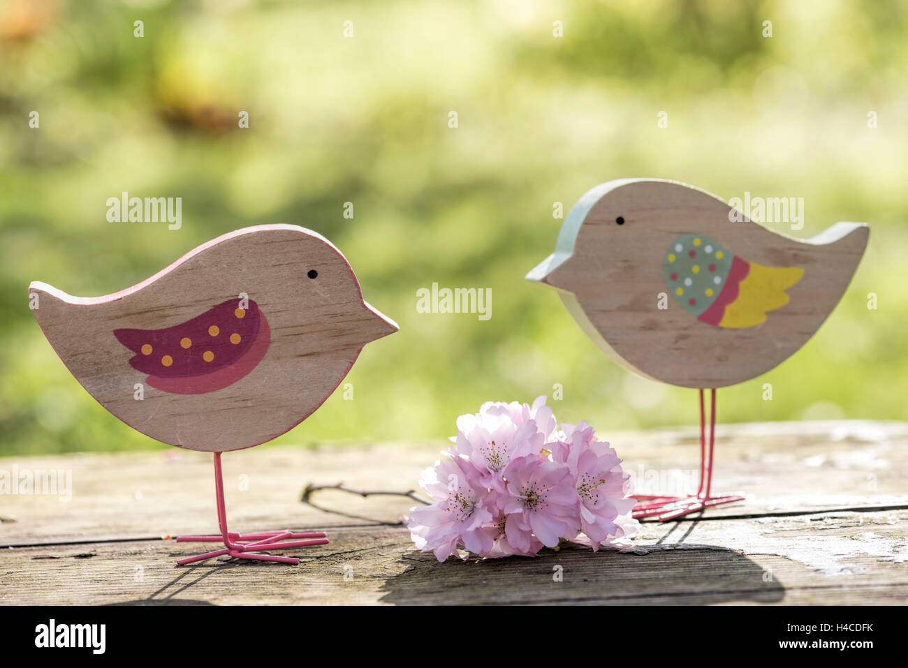 Two small wooden birds in the tread on old wood bank, decorates with ...