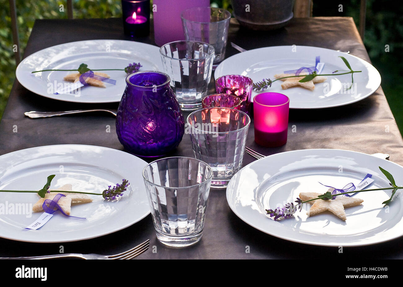 well-laid table with Underplates in teh evening Stock Photo - Alamy