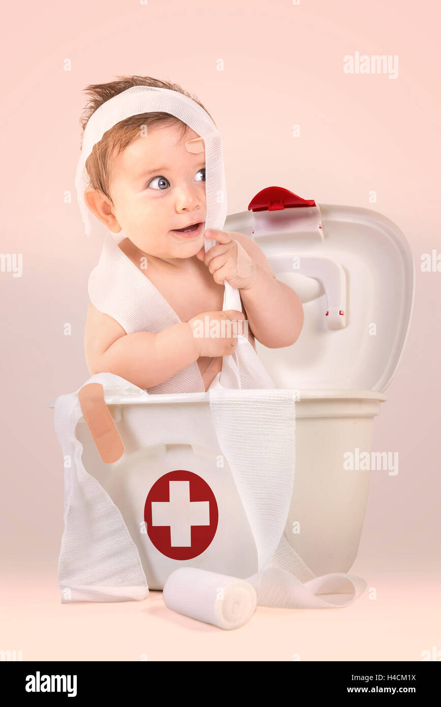 Cute baby boy playing with bandages in a first aid kit box Stock Photo ...