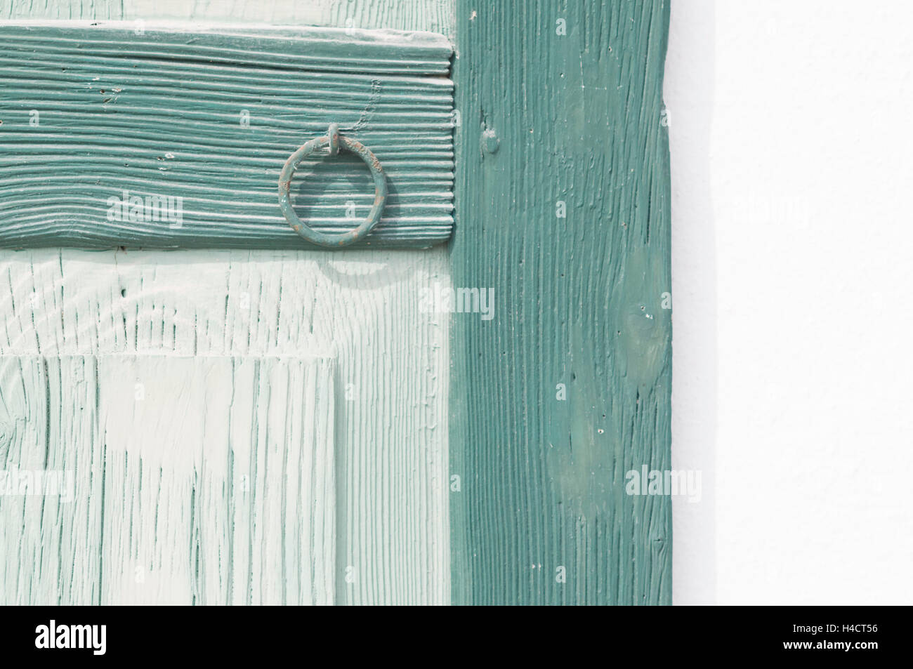 Shutter in green-blue tones with a ring in front of a white wall Stock ...
