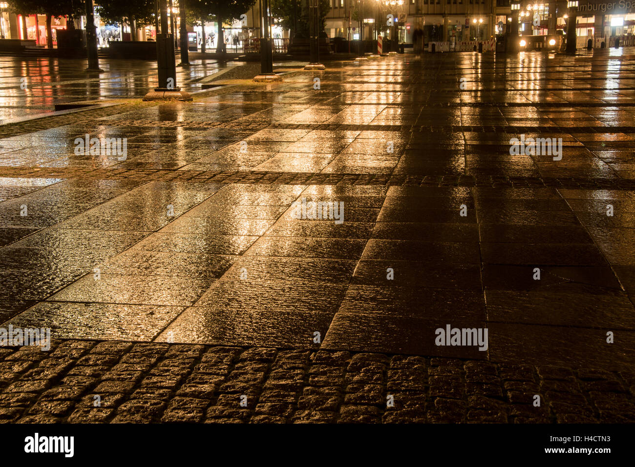 big square in the city with bright reflection light at a rainy night ...