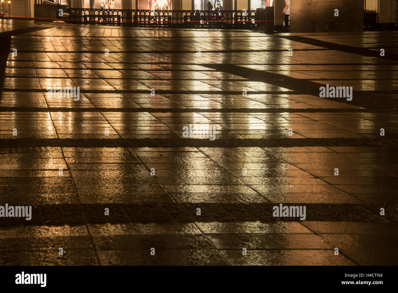 big square in the city reflecting city illumination at a rainy night ...