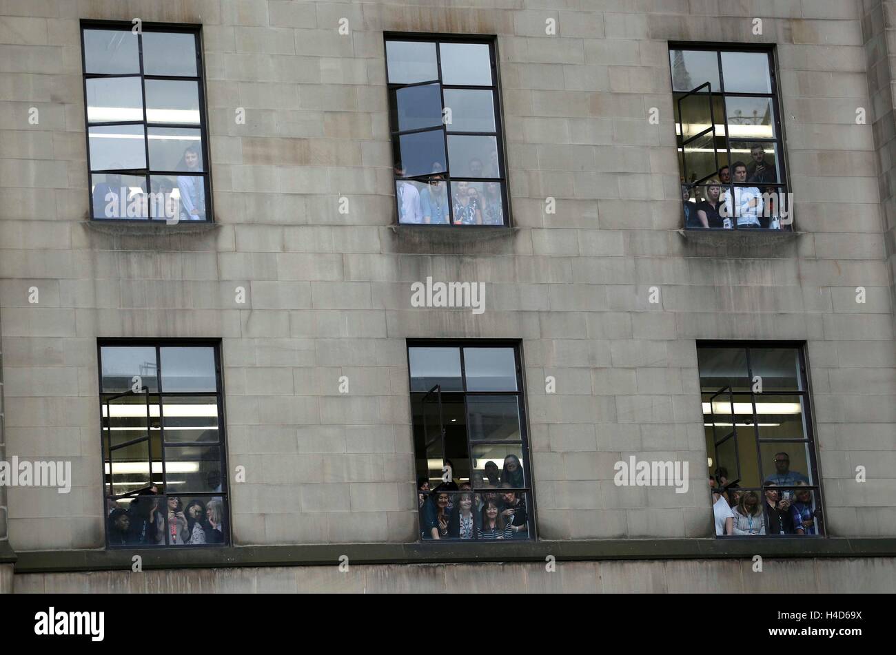 People look out of windows as they watch the Duke and Duchess of ...