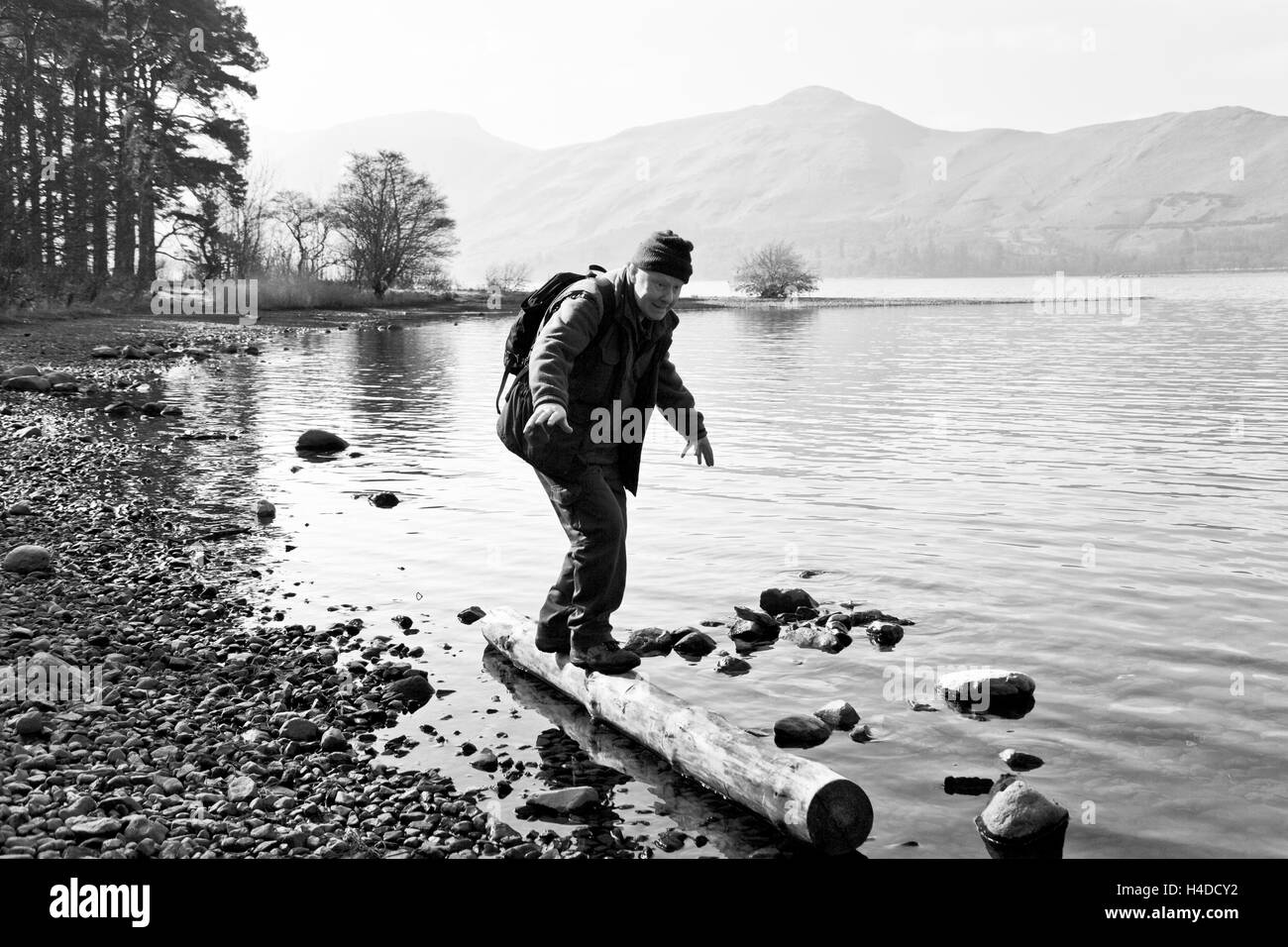 Middle aged man balancing on a log Stock Photo - Alamy