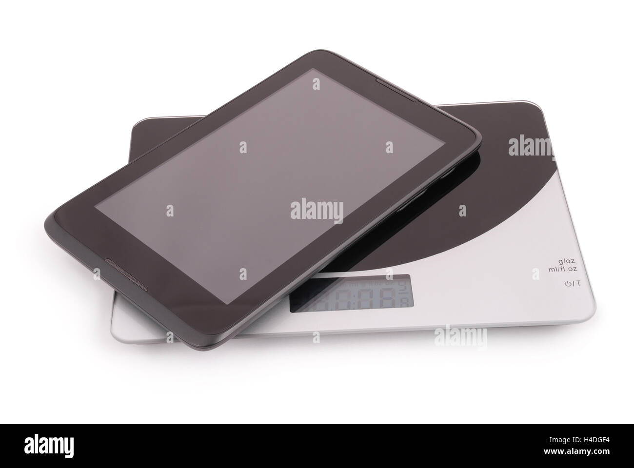 Black tablet pc isolated lies on the scales on a white background ...