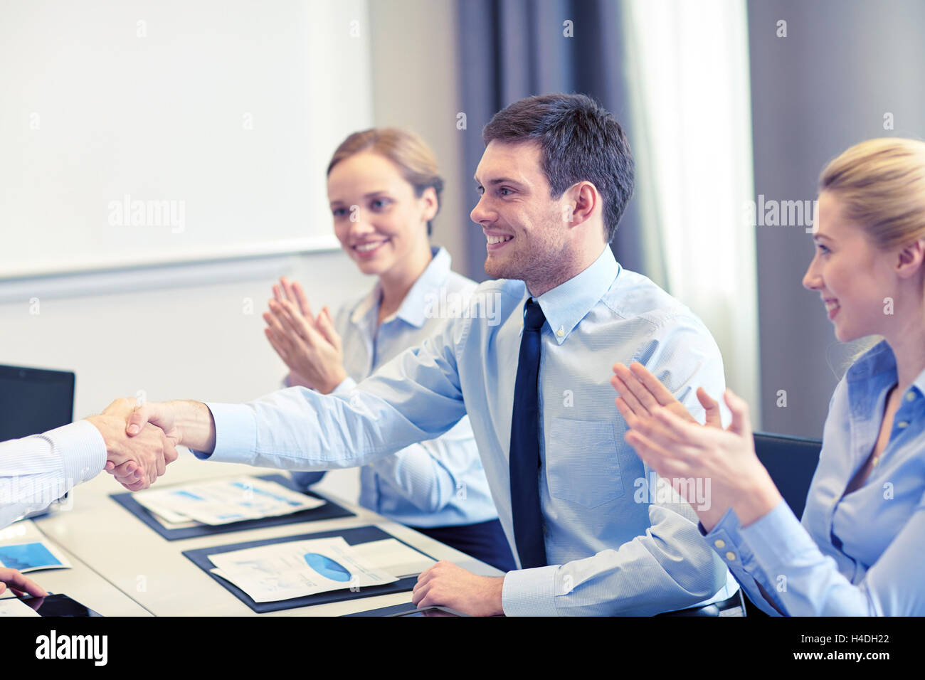 smiling business team shaking hands in office Stock Photo - Alamy