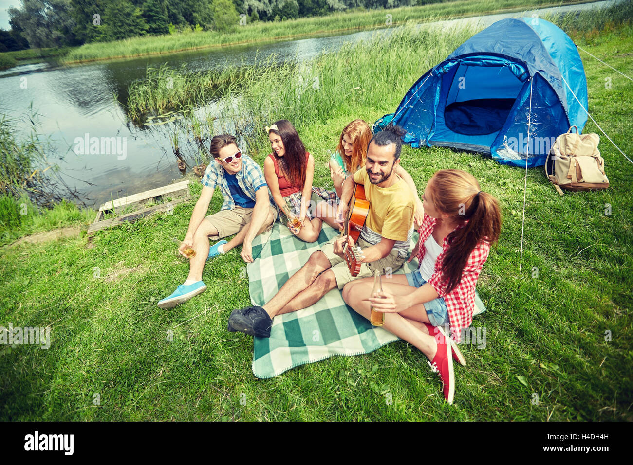 happy friends with drinks and guitar at camping Stock Photo - Alamy