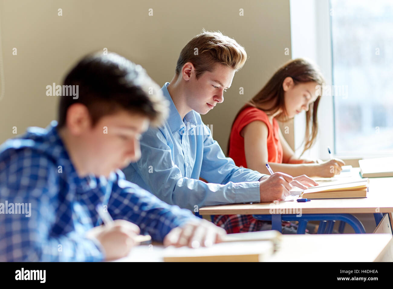group of students with books writing school test Stock Photo - Alamy