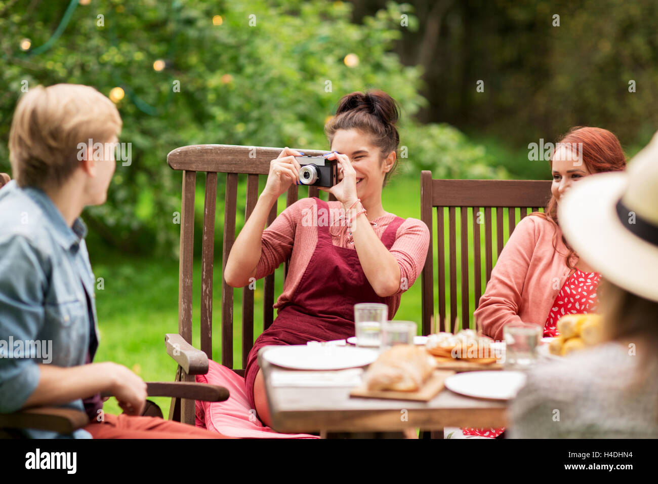 friends photographing with camera at summer party Stock Photo - Alamy