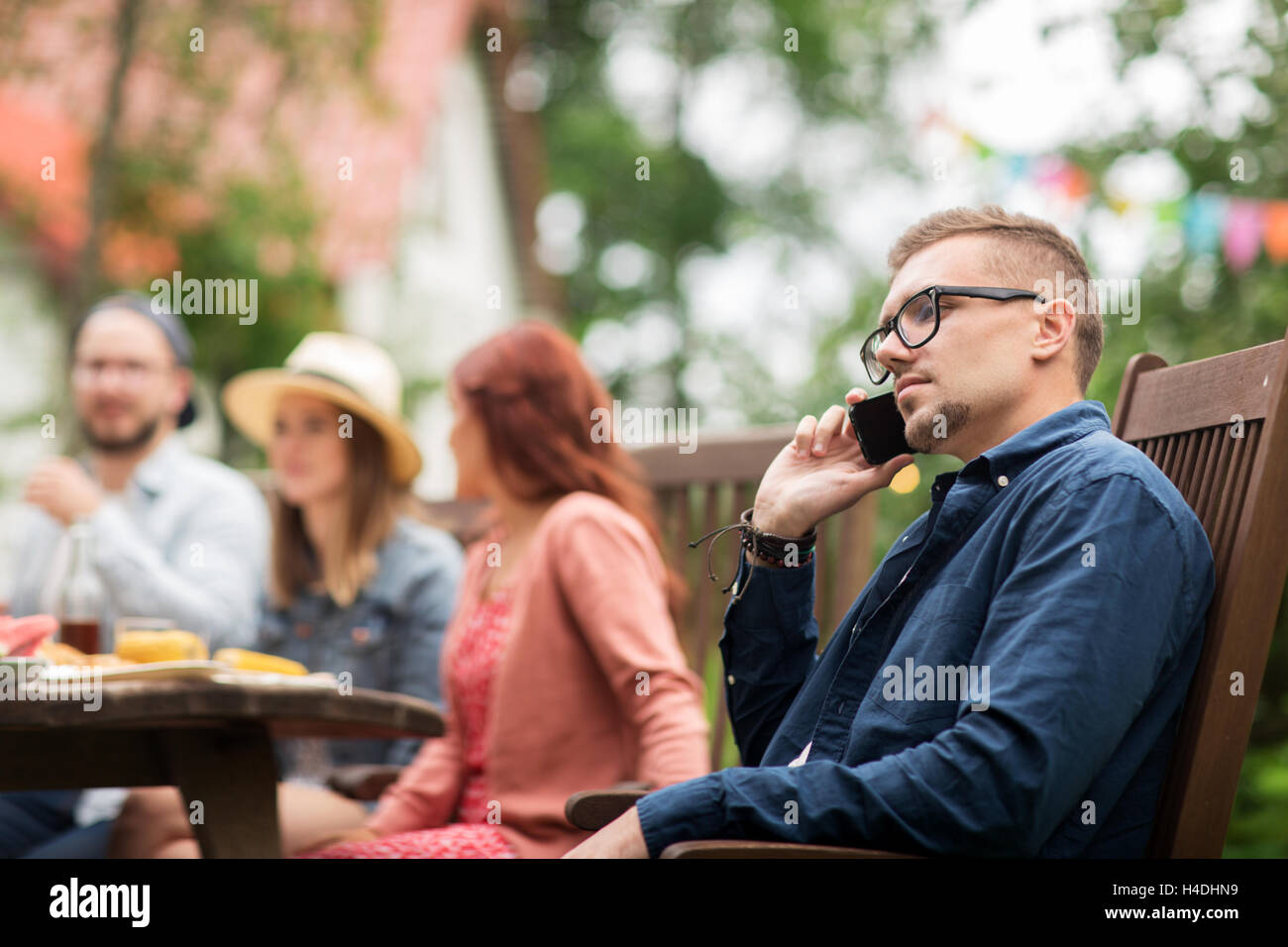 man with smartphone and friends at summer party Stock Photo - Alamy