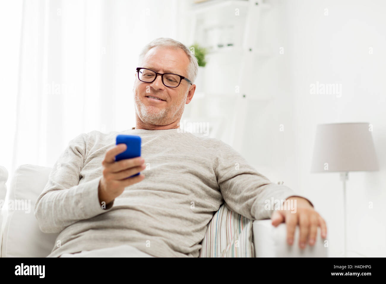 happy senior man texting on smartphone at home Stock Photo - Alamy
