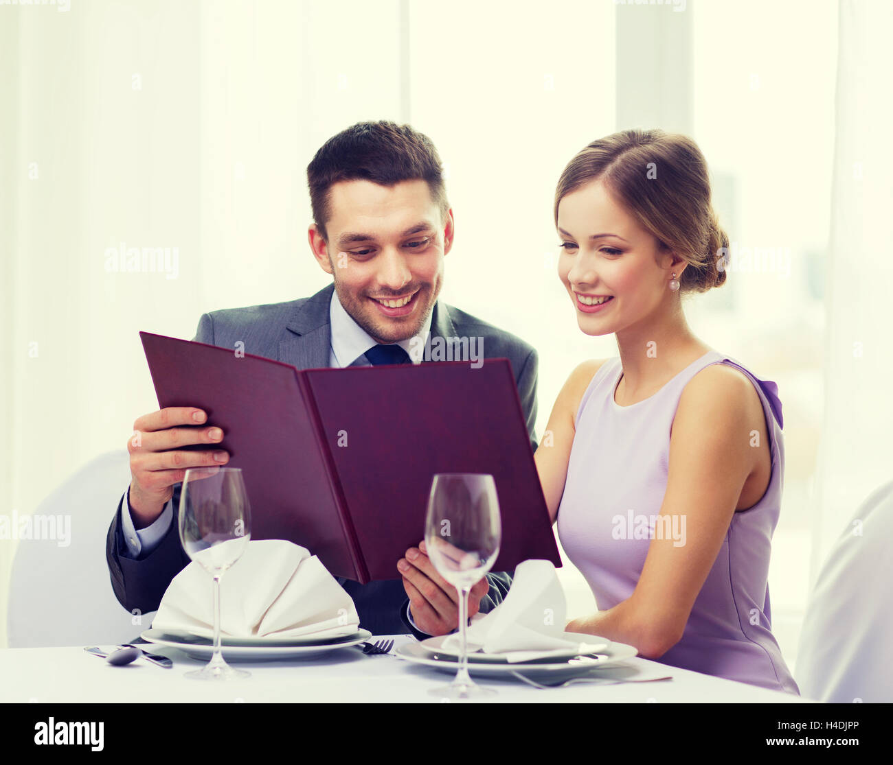 smiling couple with menu at restaurant Stock Photo - Alamy