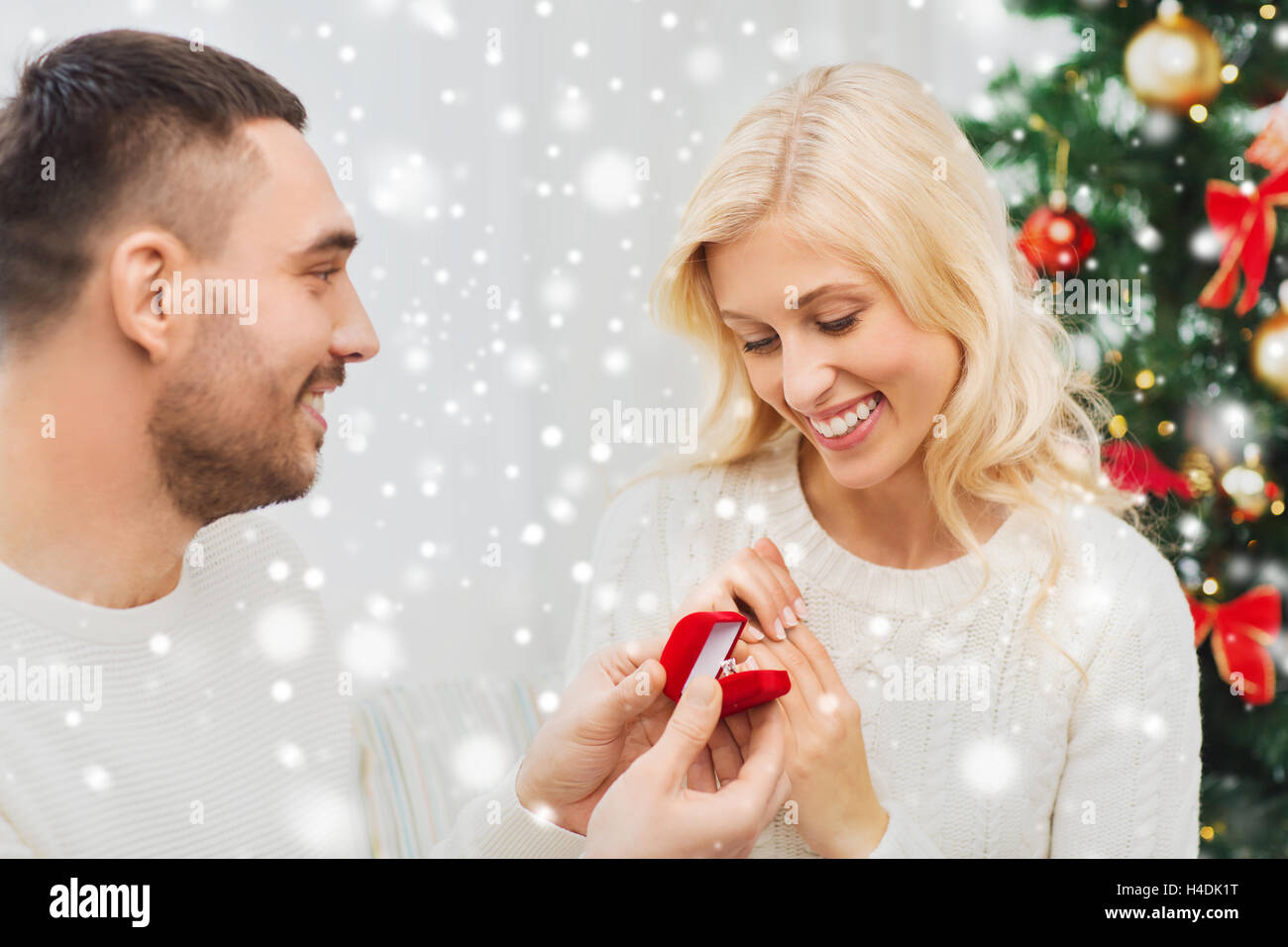 man giving woman engagement ring for christmas Stock Photo - Alamy