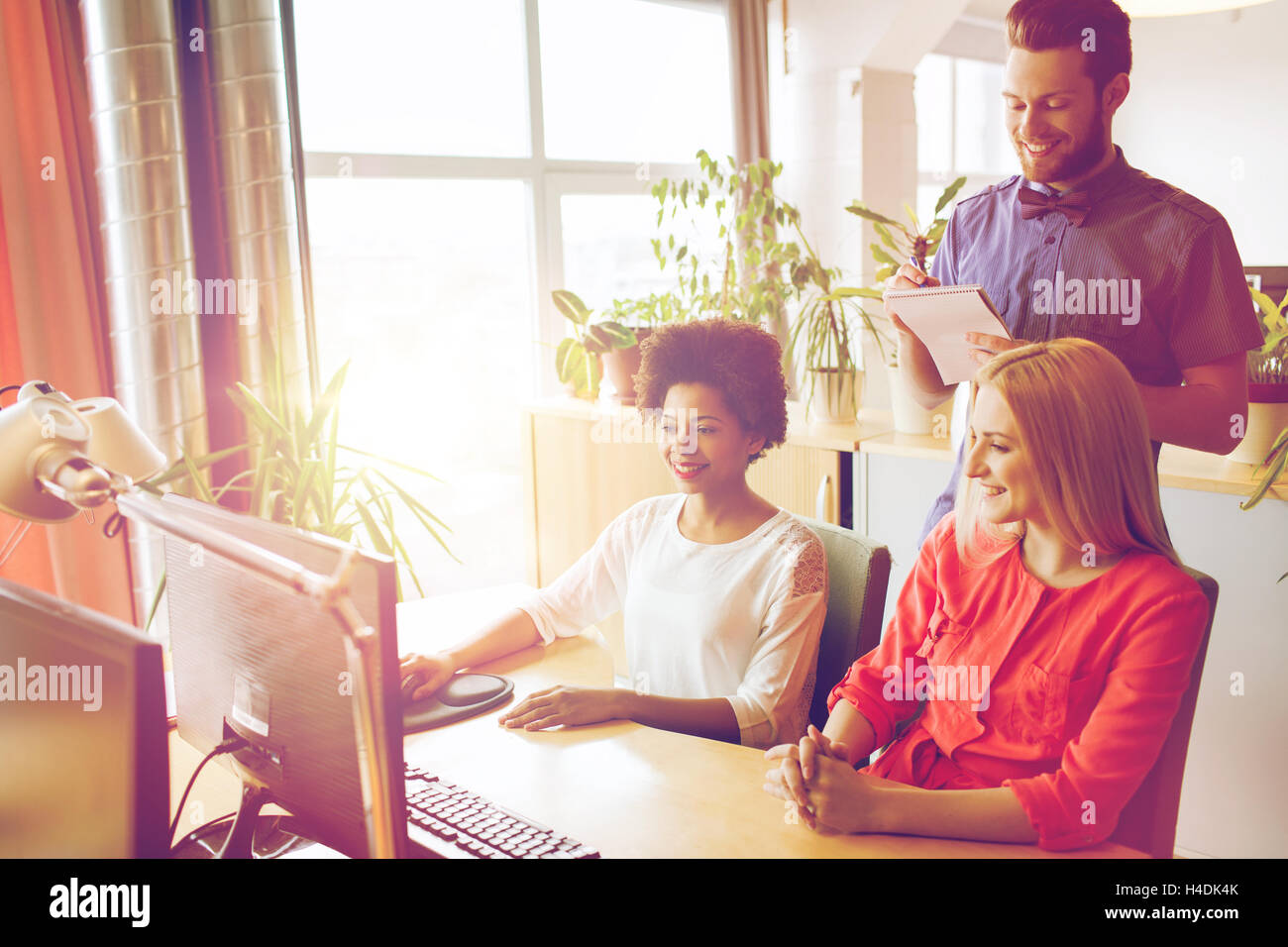 happy creative team with computer in office Stock Photo - Alamy