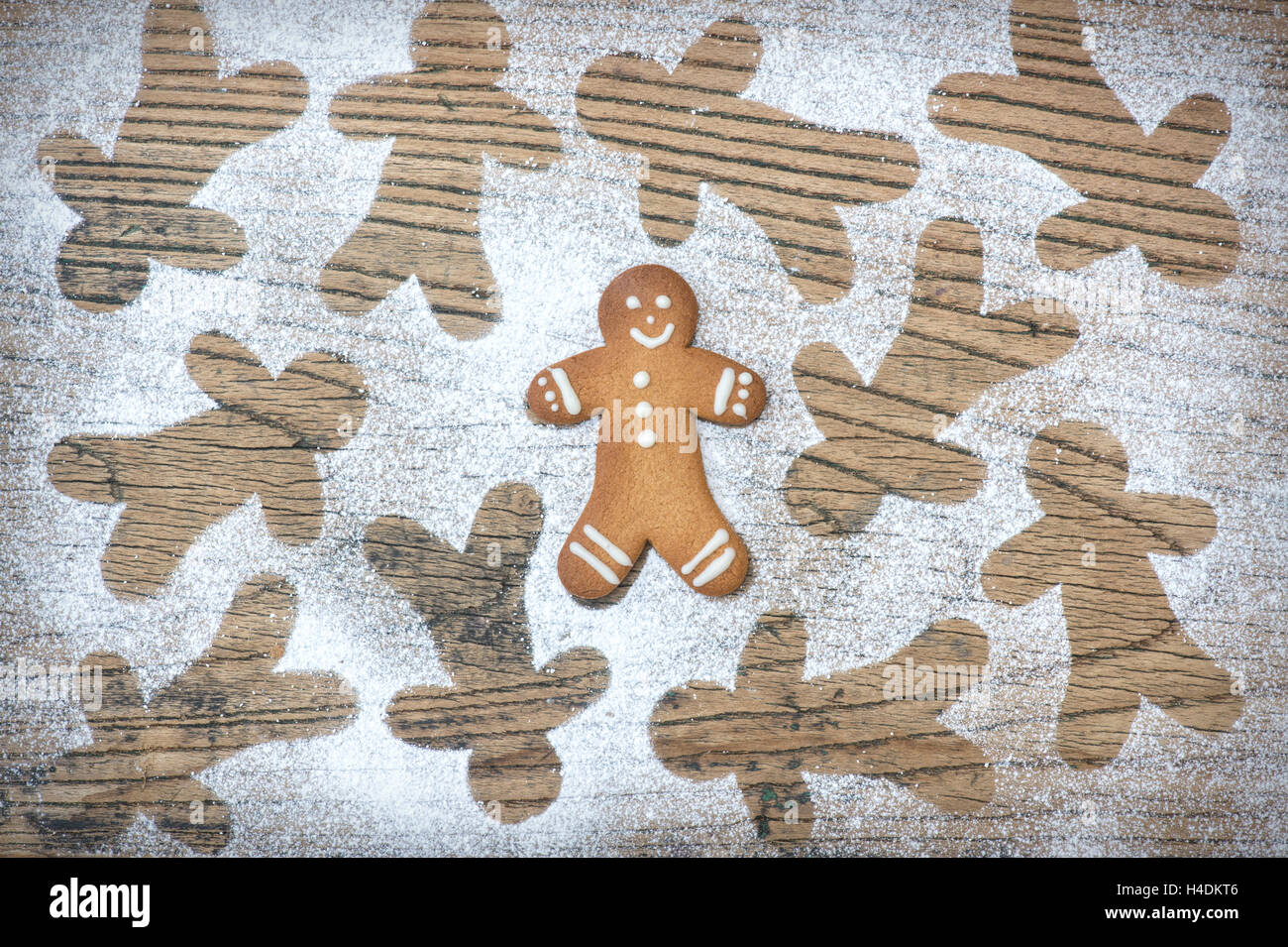 Gingerbread Man biscuit and icing sugar impressions on wood Stock Photo ...