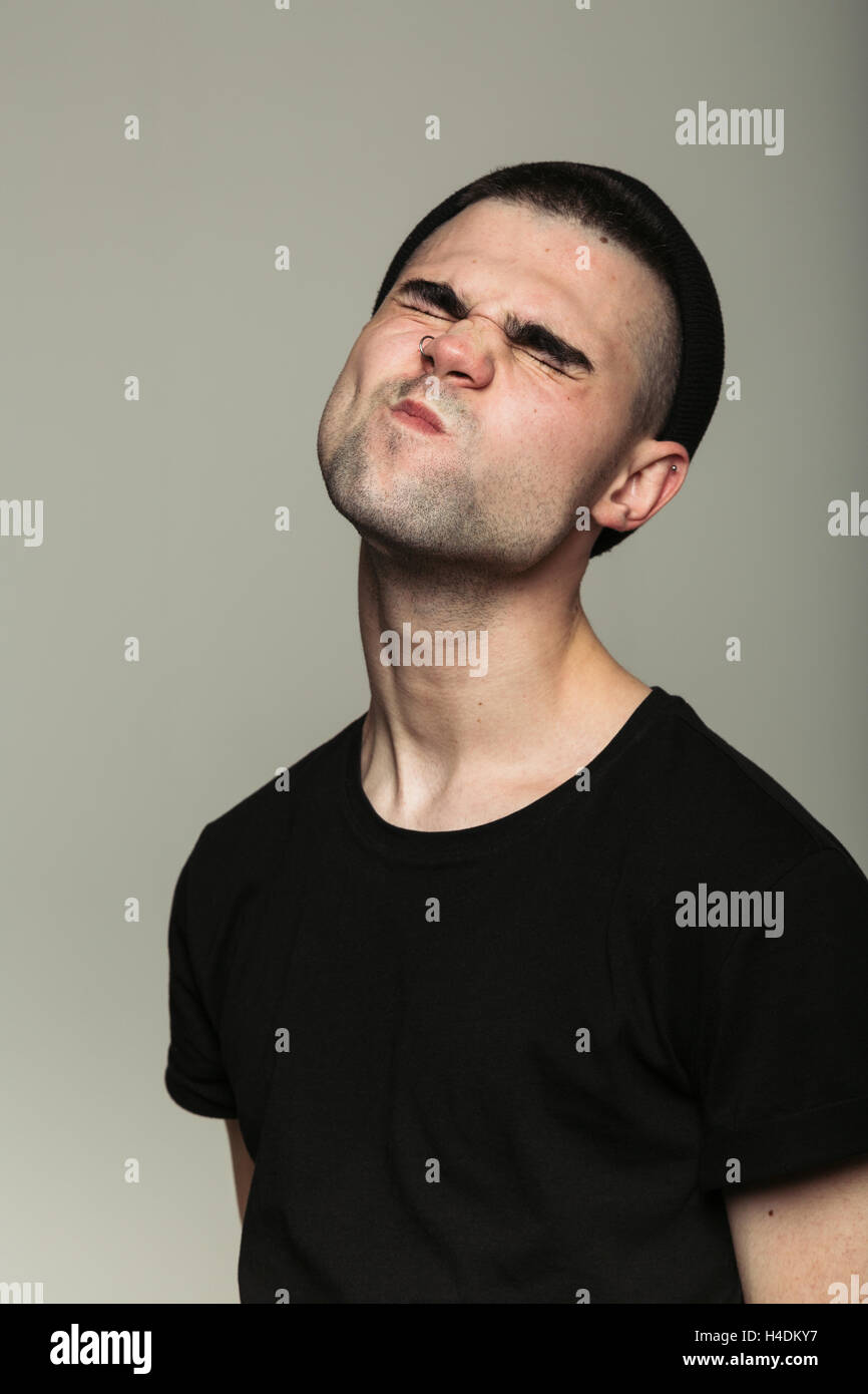 Studio portrait of young man making face Stock Photo - Alamy