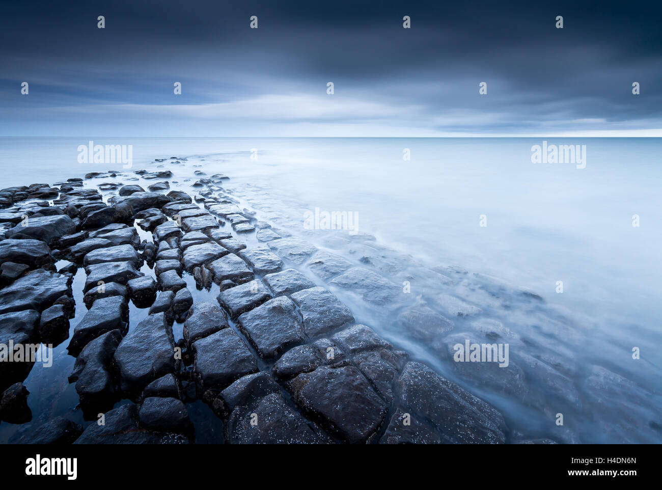 Partially submerged line of rocks like crazy paving leading out into ...
