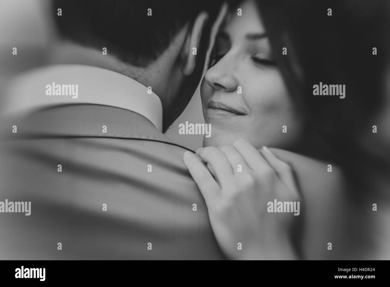 black and white photo of young happy bride embraces groom soft focus ...