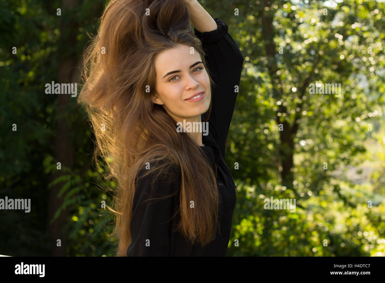 Young woman fixing her hair Stock Photo - Alamy