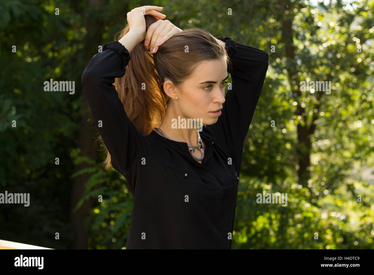 Young woman fixing her hair Stock Photo - Alamy