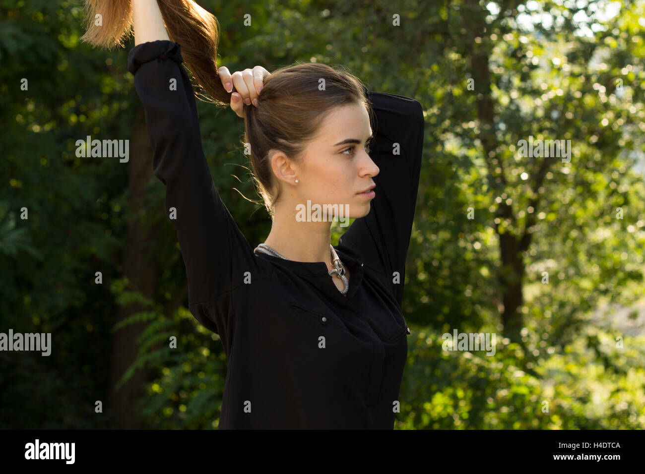 Young woman fixing her hair Stock Photo - Alamy