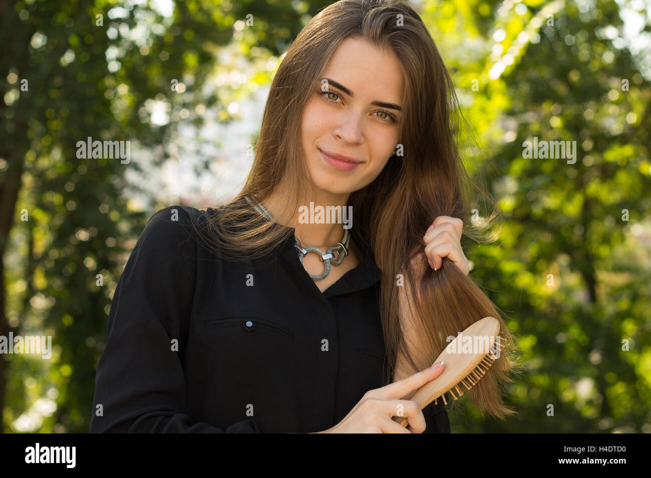 Woman combing her hair in the park Stock Photo - Alamy