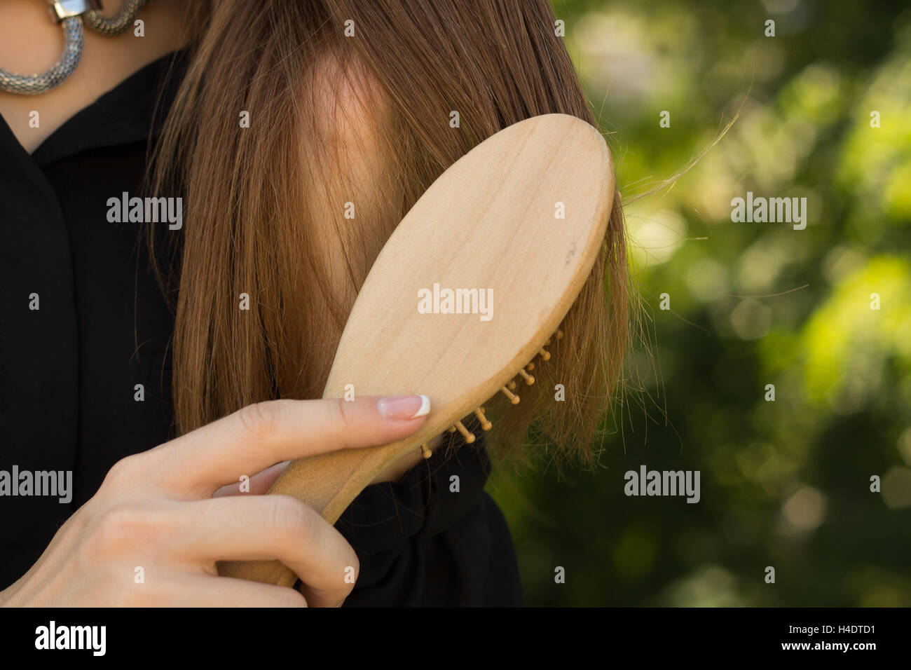 Woman combing her hair in the park Stock Photo - Alamy