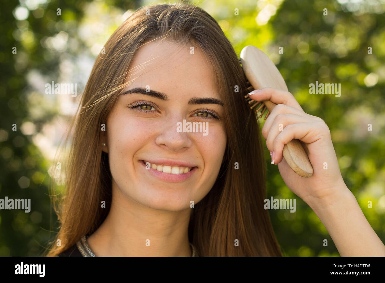 Woman combing her hair in the park Stock Photo - Alamy