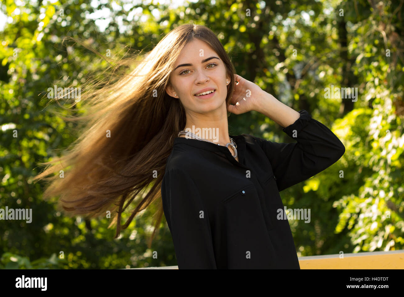 Young woman touching her hair Stock Photo - Alamy
