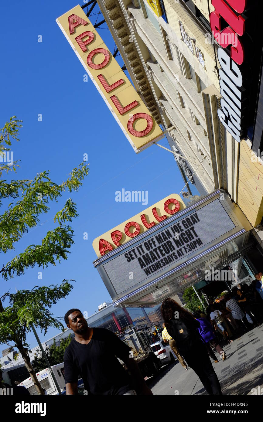 Pedestrians on 125th street with sign of Apollo Theater on the entrance ...