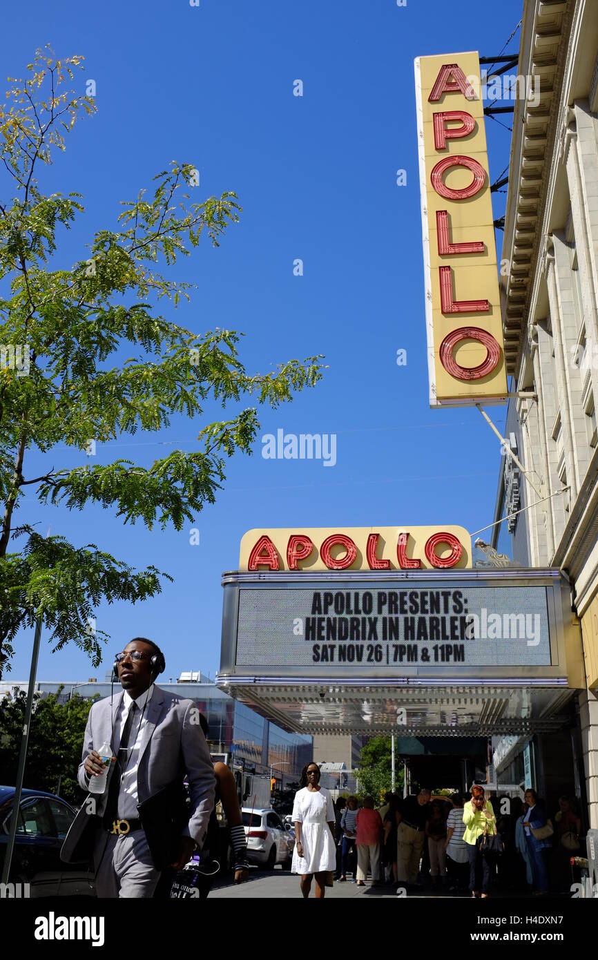 Pedestrians on 125th street with sign of Apollo Theater on the entrance ...