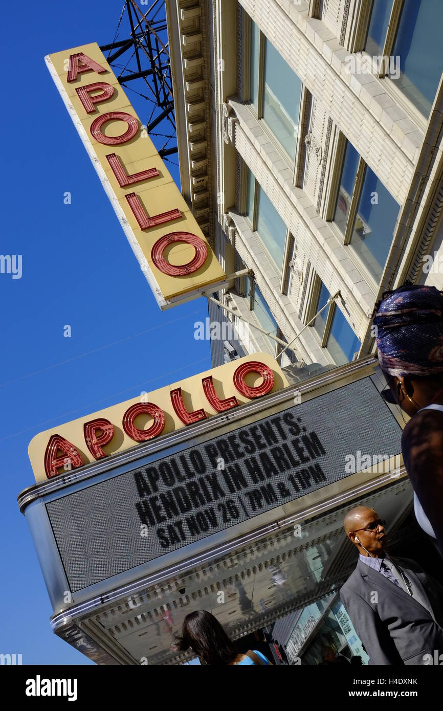 Pedestrians on 125th street with sign of Apollo Theater on the entrance ...