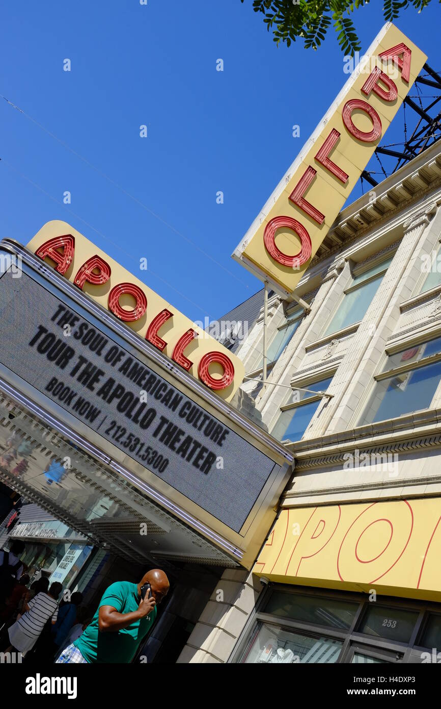 Pedestrians on 125th street with sign of Apollo Theater on the entrance ...