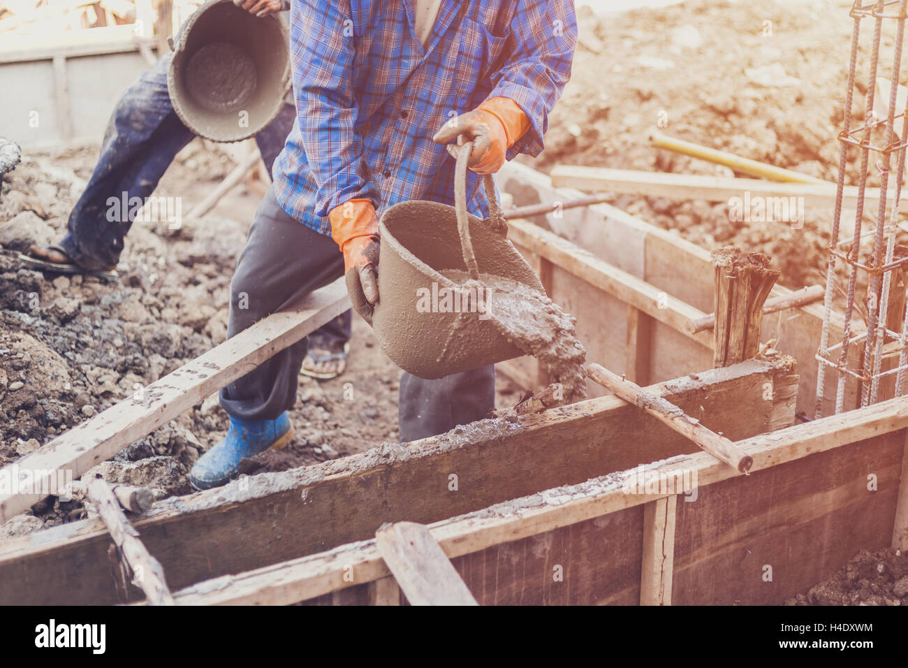 man worker mixing cement mortar plaster for construction with vintage ...