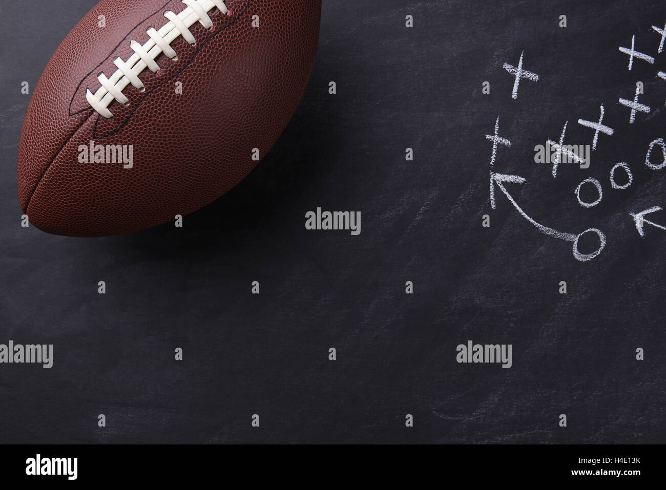 Top view of an American style football on a chalkboard with a play ...