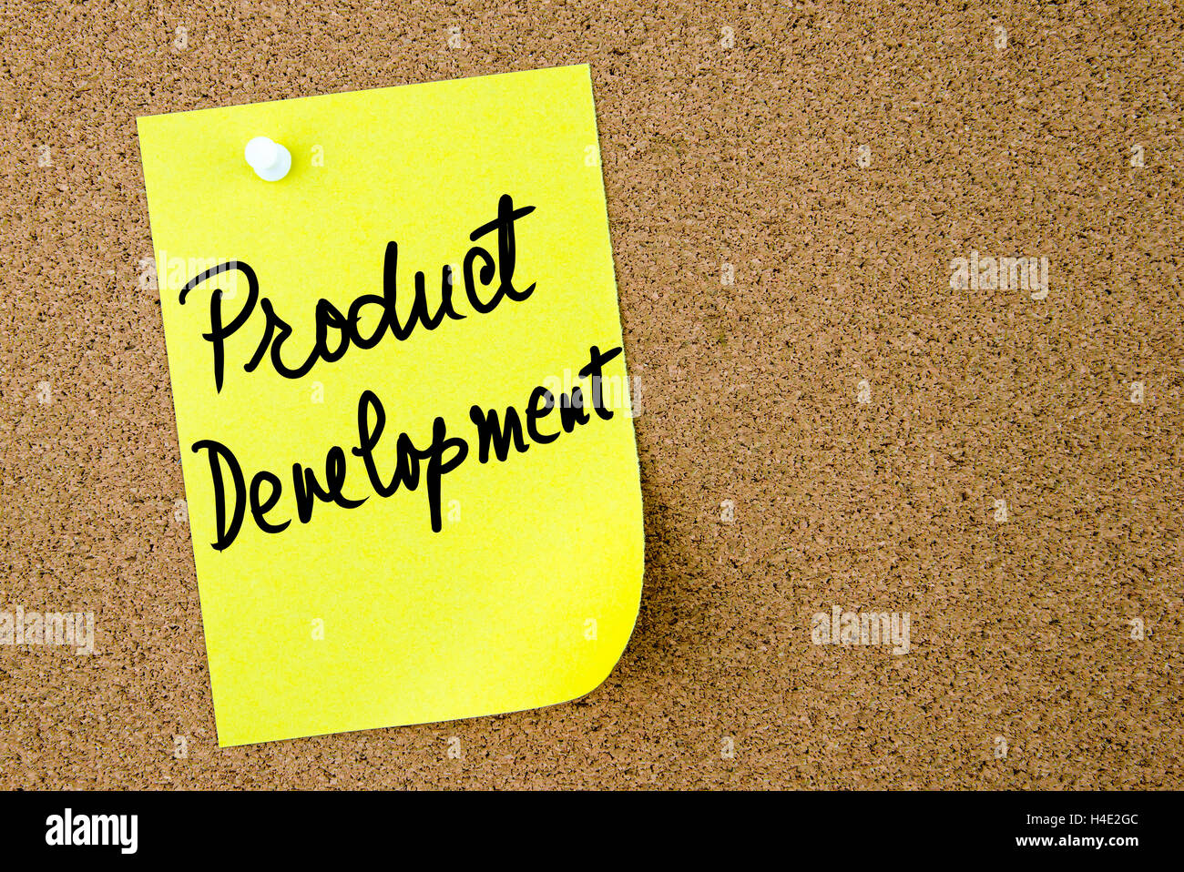 Product Development text written on yellow paper note pinned on cork ...