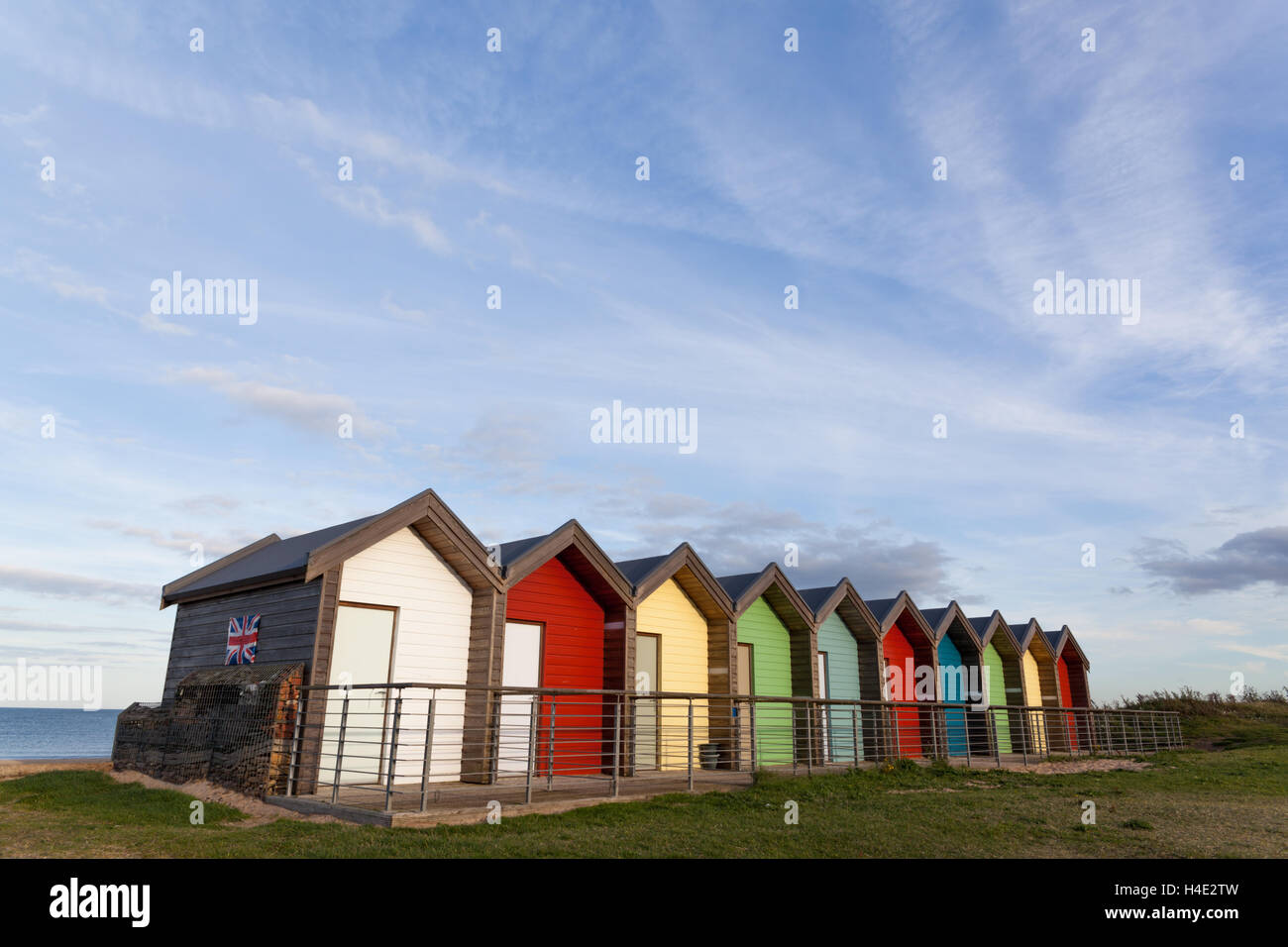 A row of multi-coloured wooden beach huts under a summer sky at Blyth ...