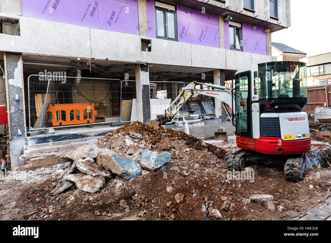 Digger and pavement being dug up during building renovations, Cardiff ...