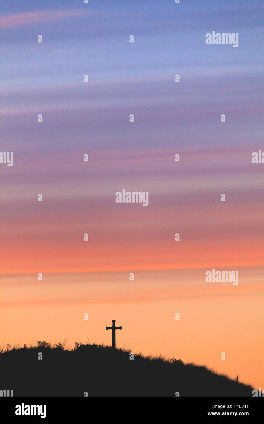 Crucifix, cross silhouette on a distant hill with a beautiful pastel ...