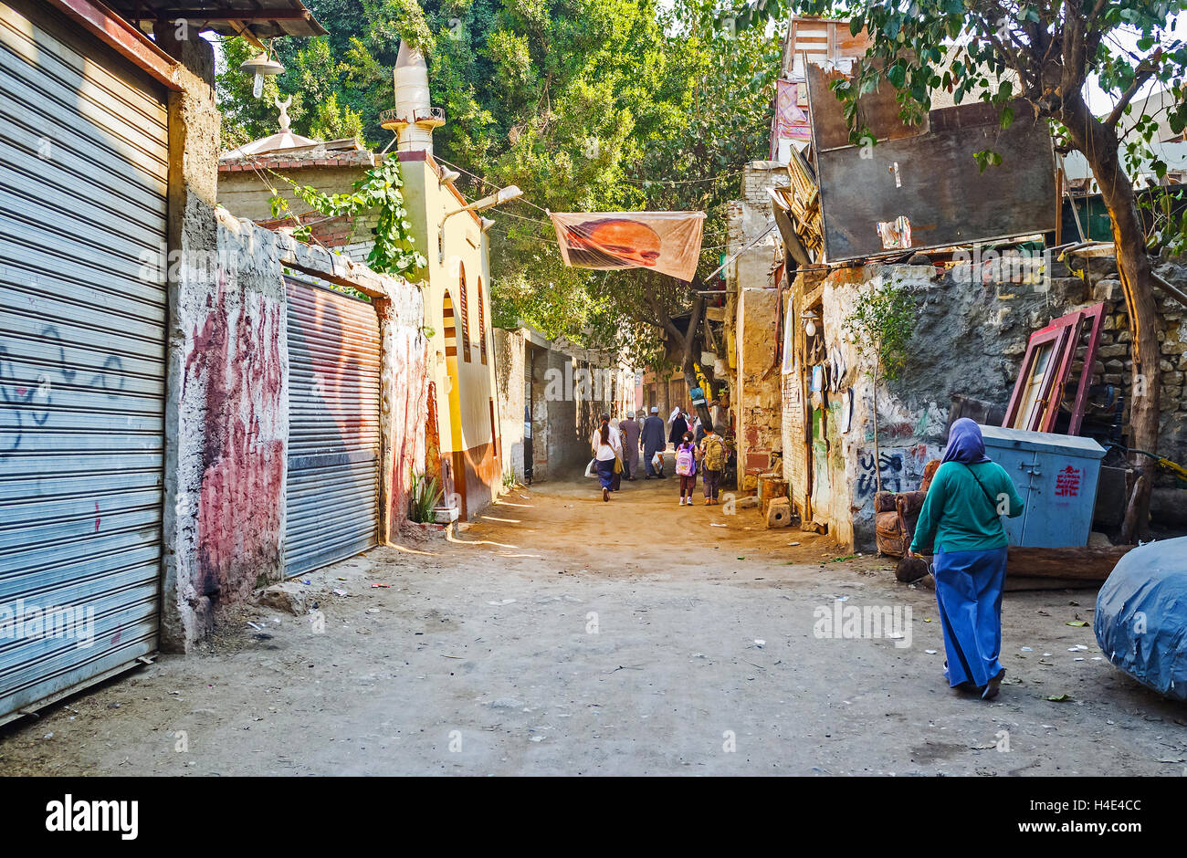 The narrow dusty street of the old poor neighborhood with the tiny ...