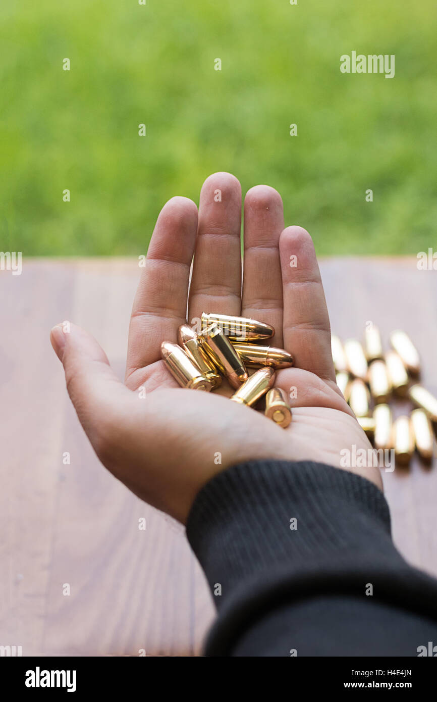 Hand with 9mm bullets. Hand holding bullets Stock Photo - Alamy