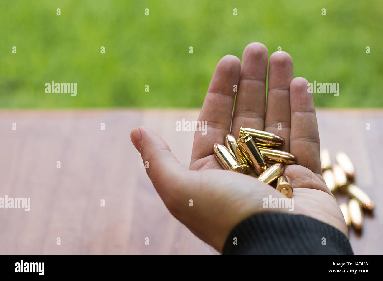 Hand with 9mm bullets. Hand holding bullets Stock Photo - Alamy