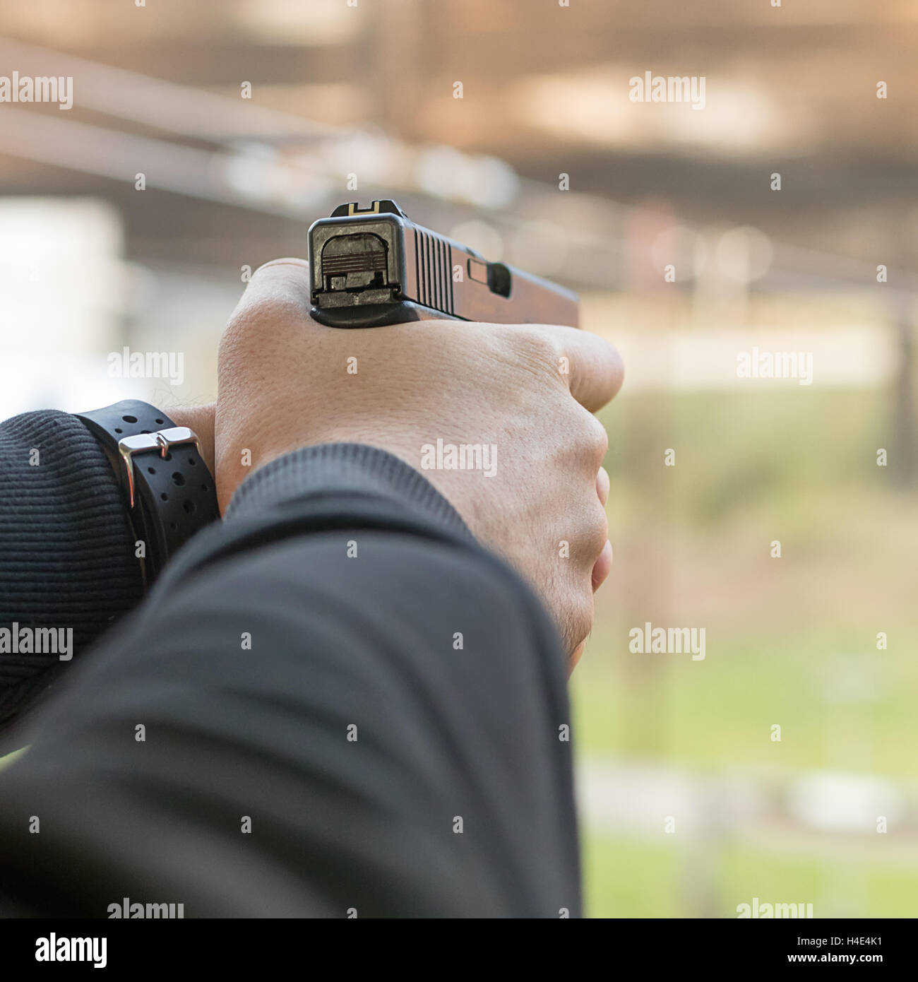 Shooting with a pistol. Man aiming pistol in shooting range Stock Photo ...