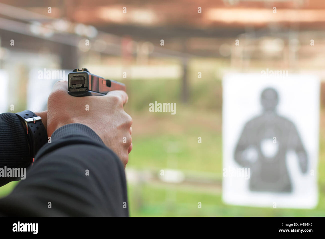 Shooting with a pistol. Man aiming pistol in shooting range Stock Photo ...