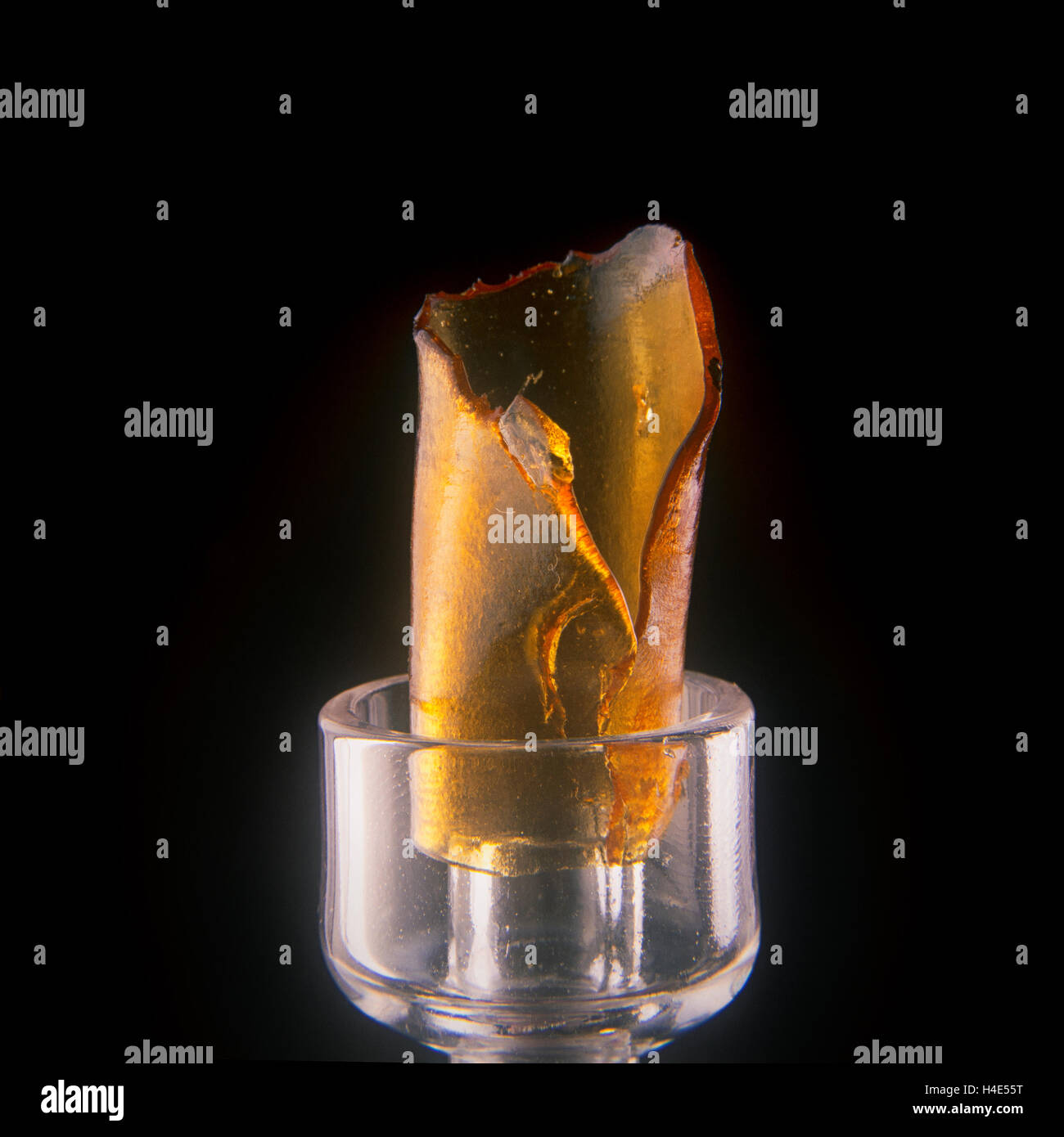 A piece of cannabis oil concentrate aka shatter with glass tools ...